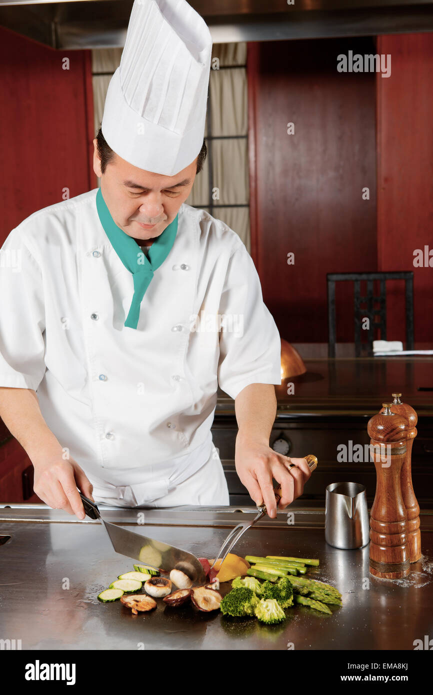 Cook prepares fried vegetable dish Stock Photo - Alamy