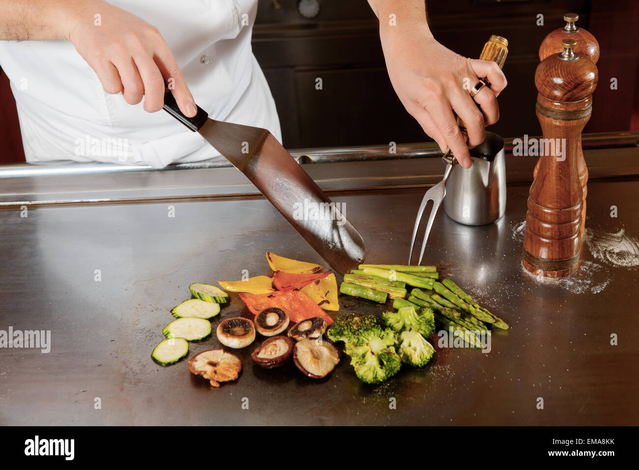 Cook prepares fried vegetable dish Stock Photo - Alamy