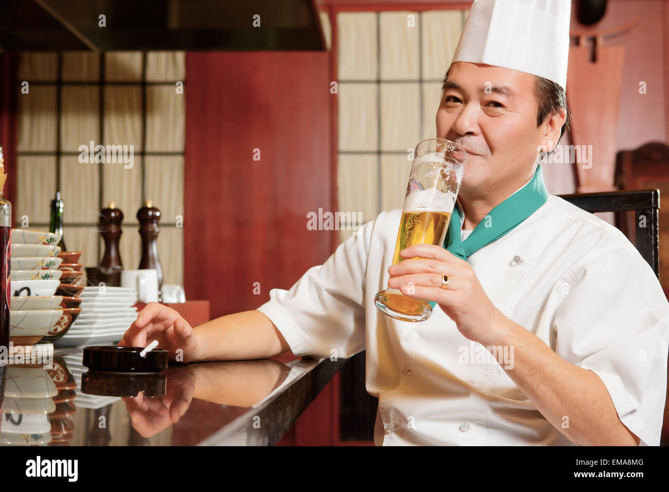 Cook has a drink in restaurant kitchen Stock Photo - Alamy