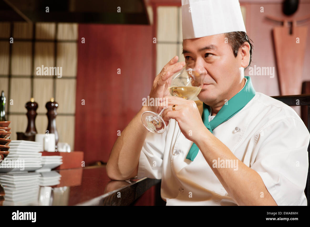 Cook has a drink in restaurant kitchen Stock Photo - Alamy