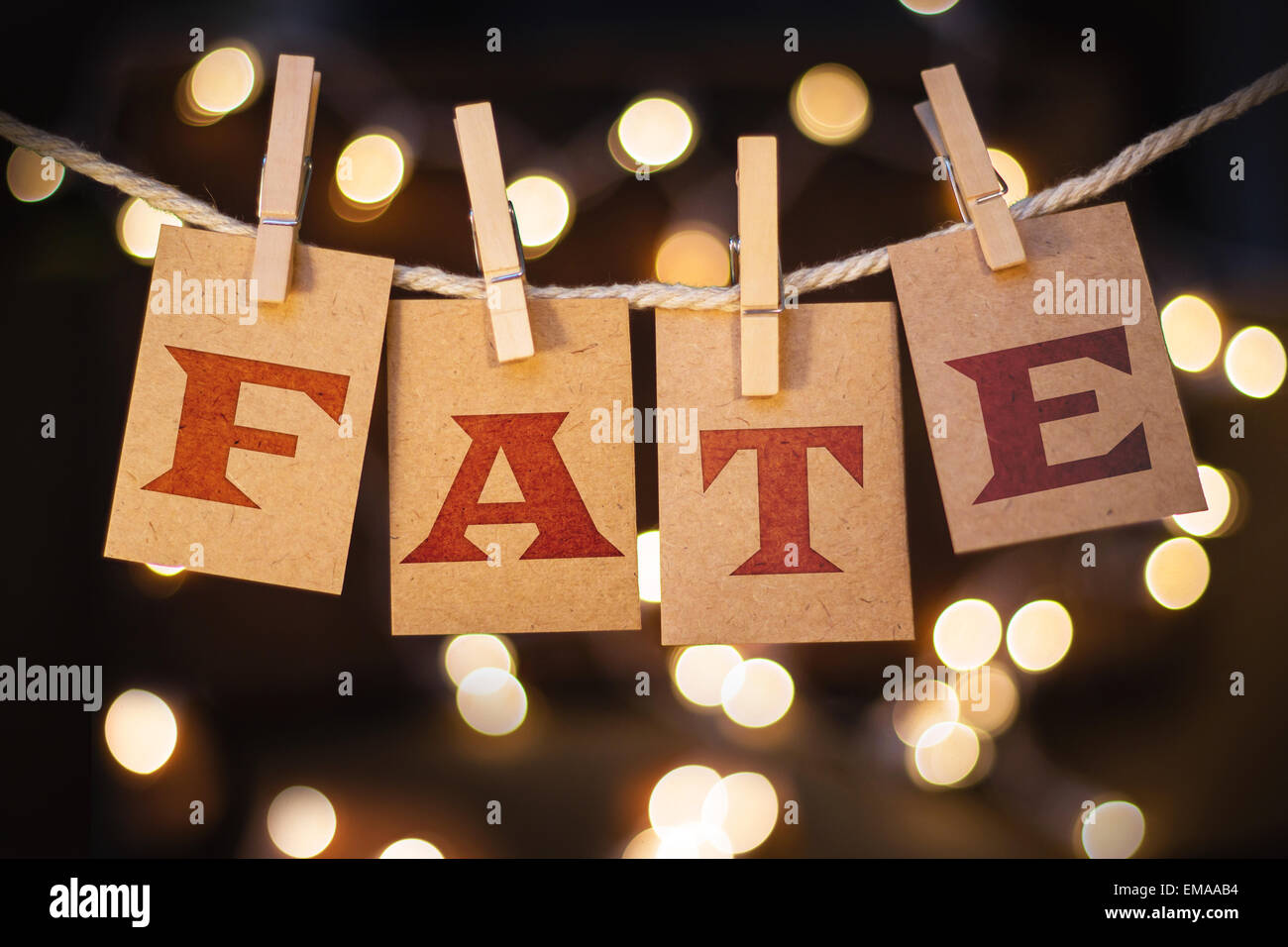 The word FATE printed on clothespin clipped cards in front of defocused ...
