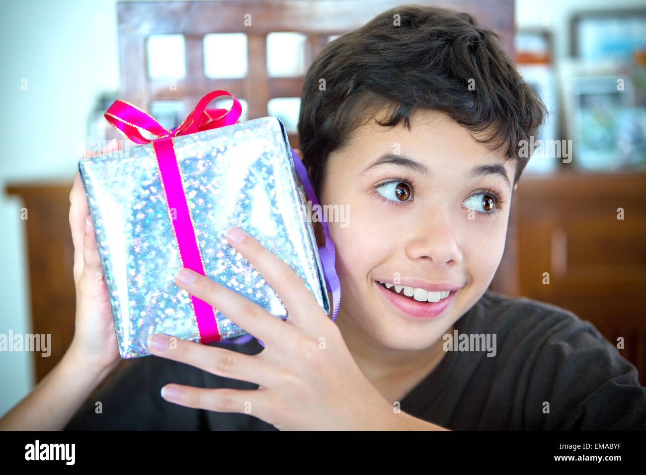 Young boy showing excitement over receiving a gift wrapped present ...