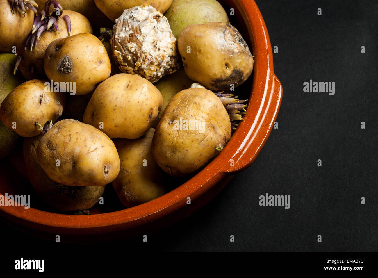 Bowl of potatoes with one rotten one Stock Photo - Alamy