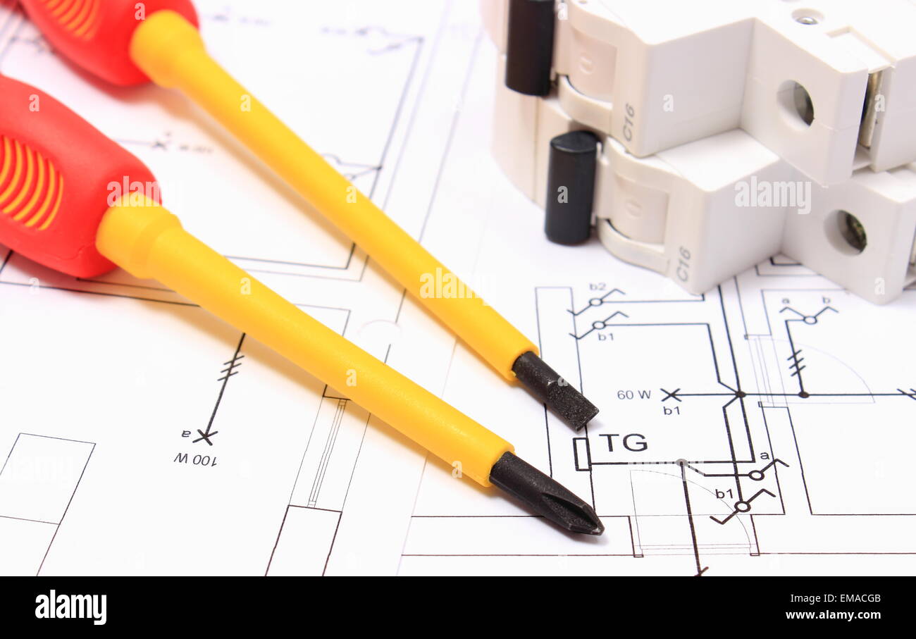 Screwdriver, work tools and electric fuse lying on construction drawing ...