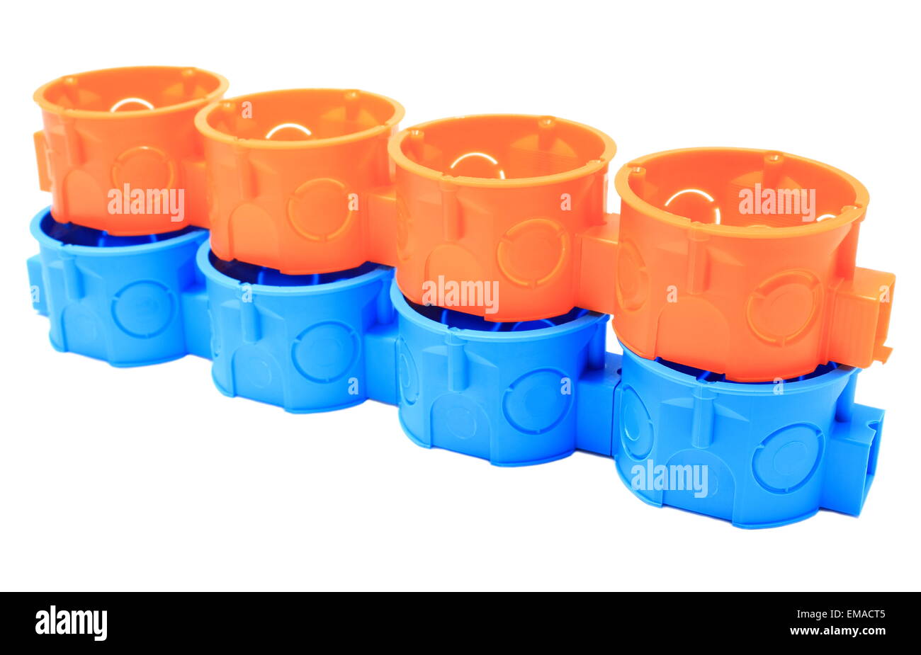 Stack of orange and blue plastic electrical boxes on white background ...