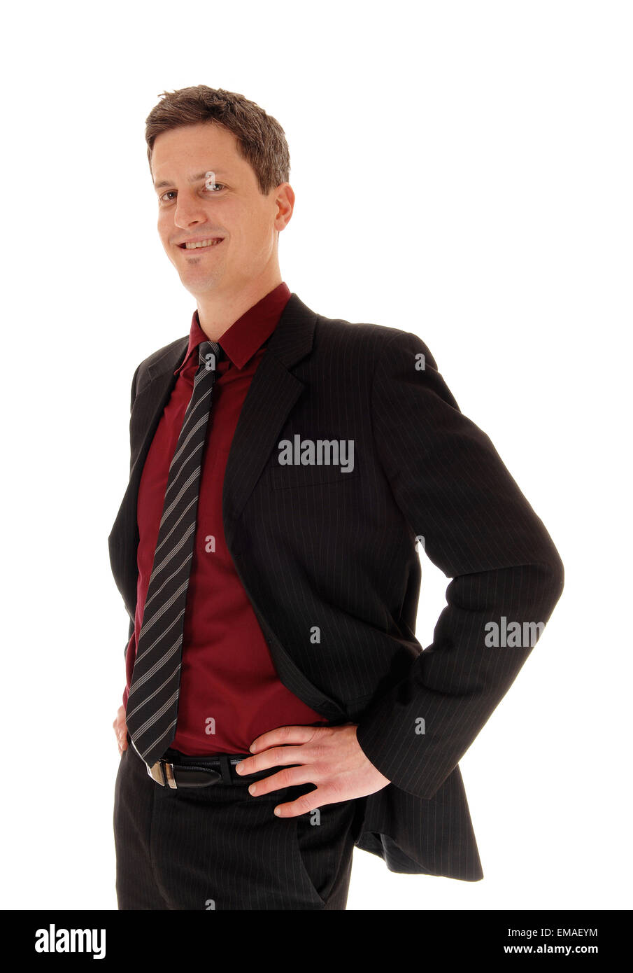 An business man in a suit and tie standing, with his hands on his hips ...