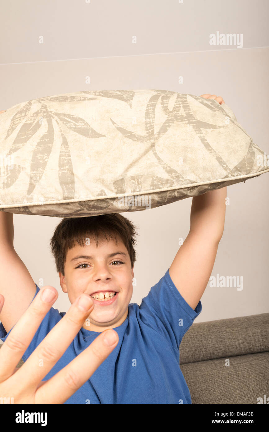 Young boy going to throw a pillow Stock Photo - Alamy