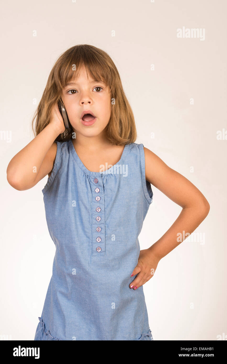 Little girl standing talking on cellphone with white background Stock ...