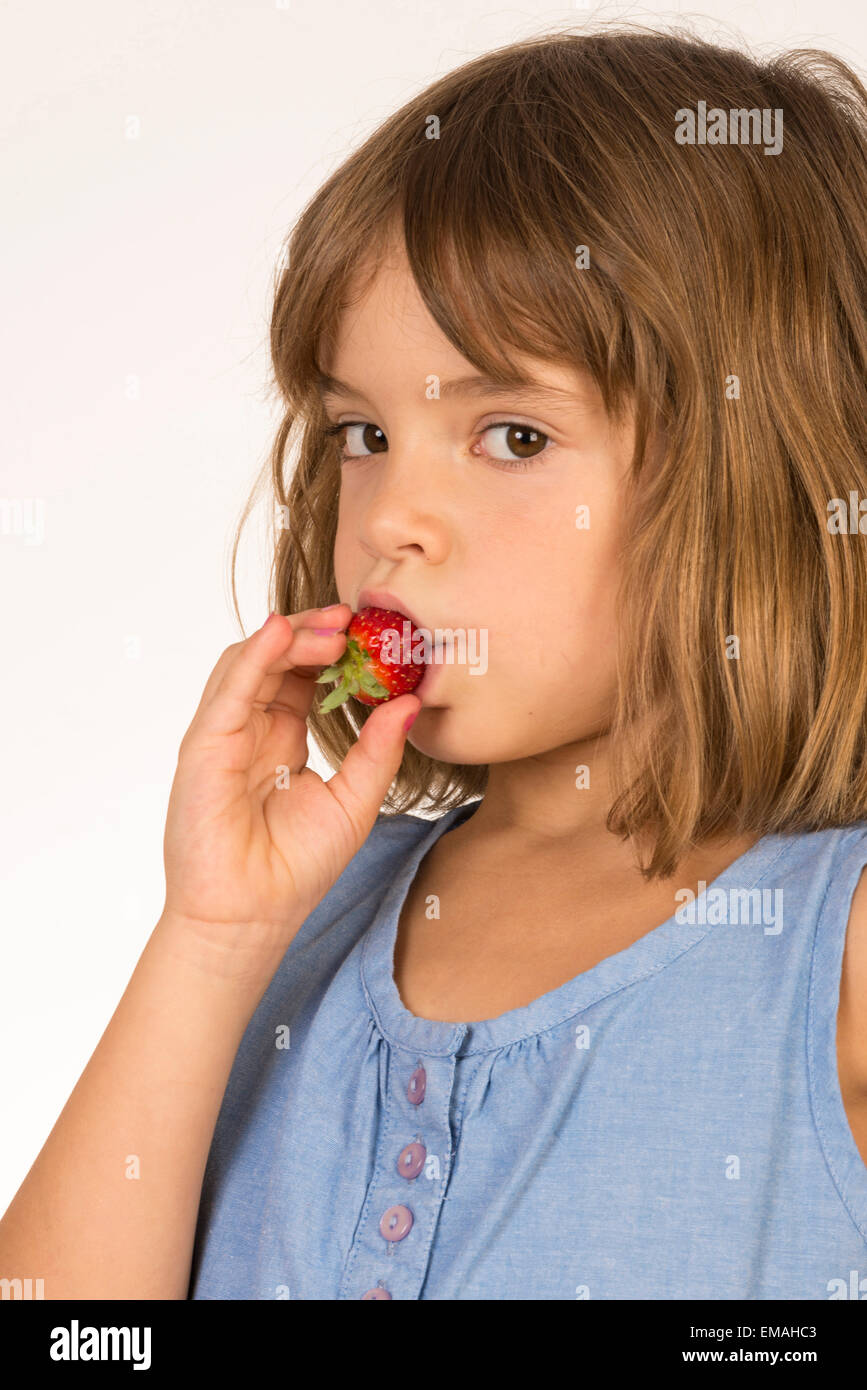 Little Girl Eating Strawberry with white background Stock Photo - Alamy