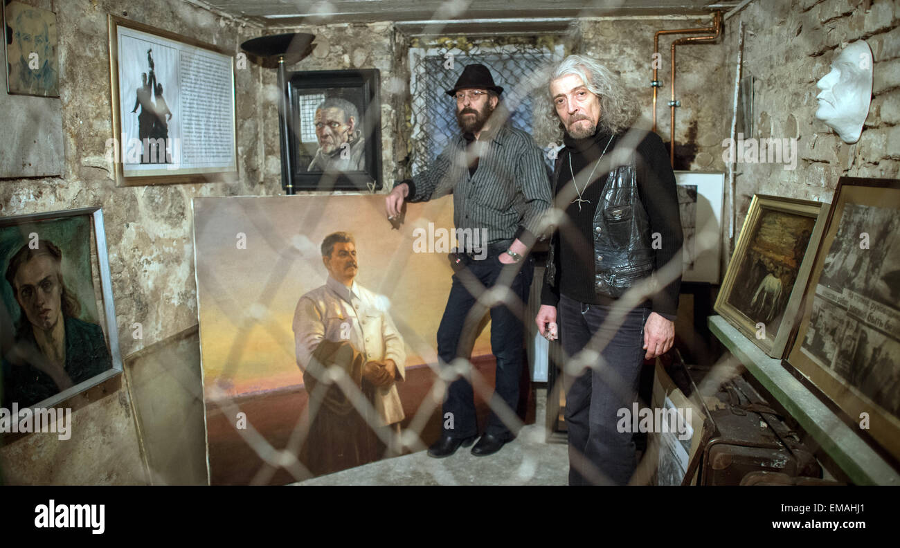 Michael (L) and Eugen Posin pose next to a painting depicting Stalin in ...