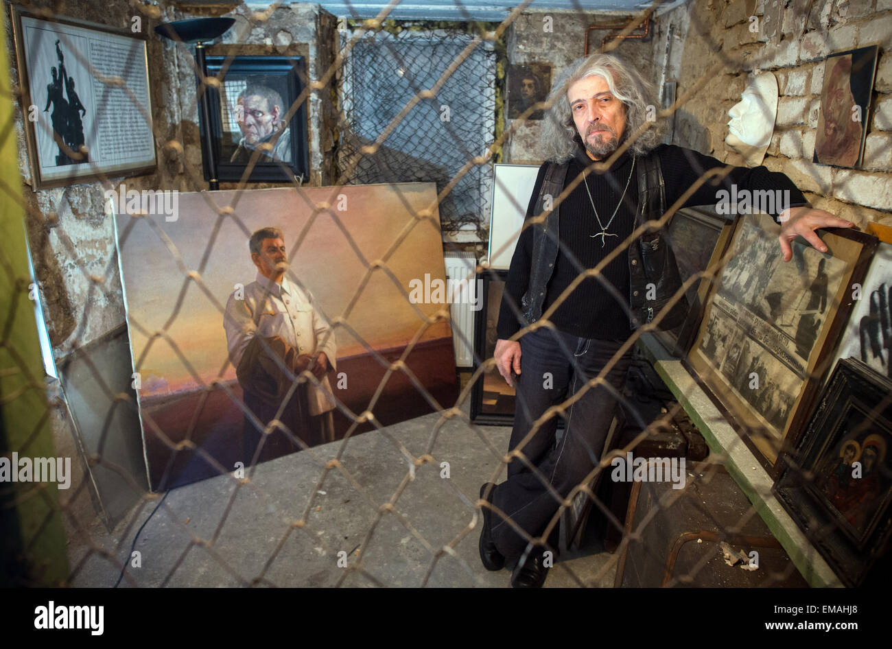 Eugen Posin, one of the three Posin brothers, poses next a painting ...