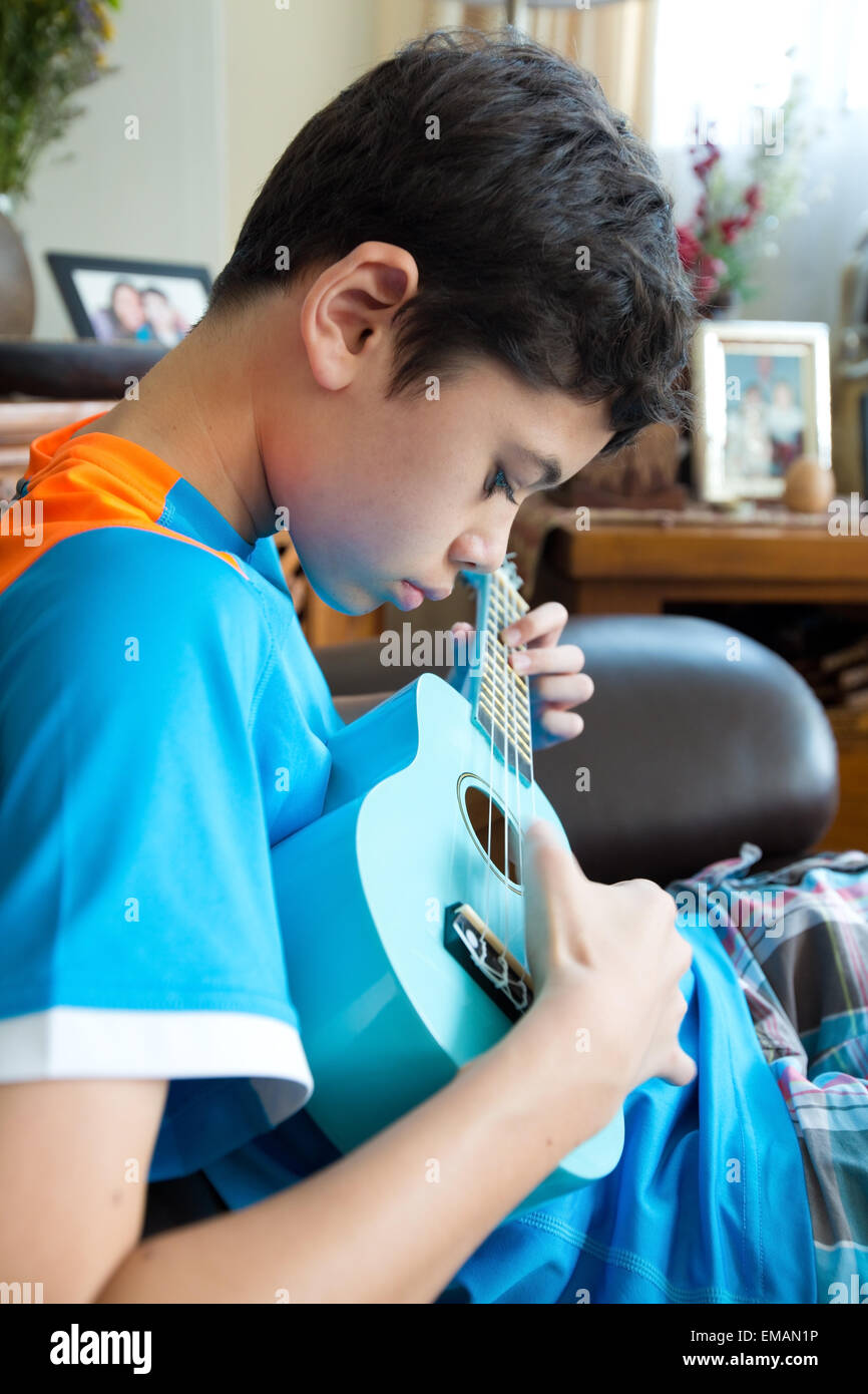 Young boy practicing on his ukulele Stock Photo - Alamy