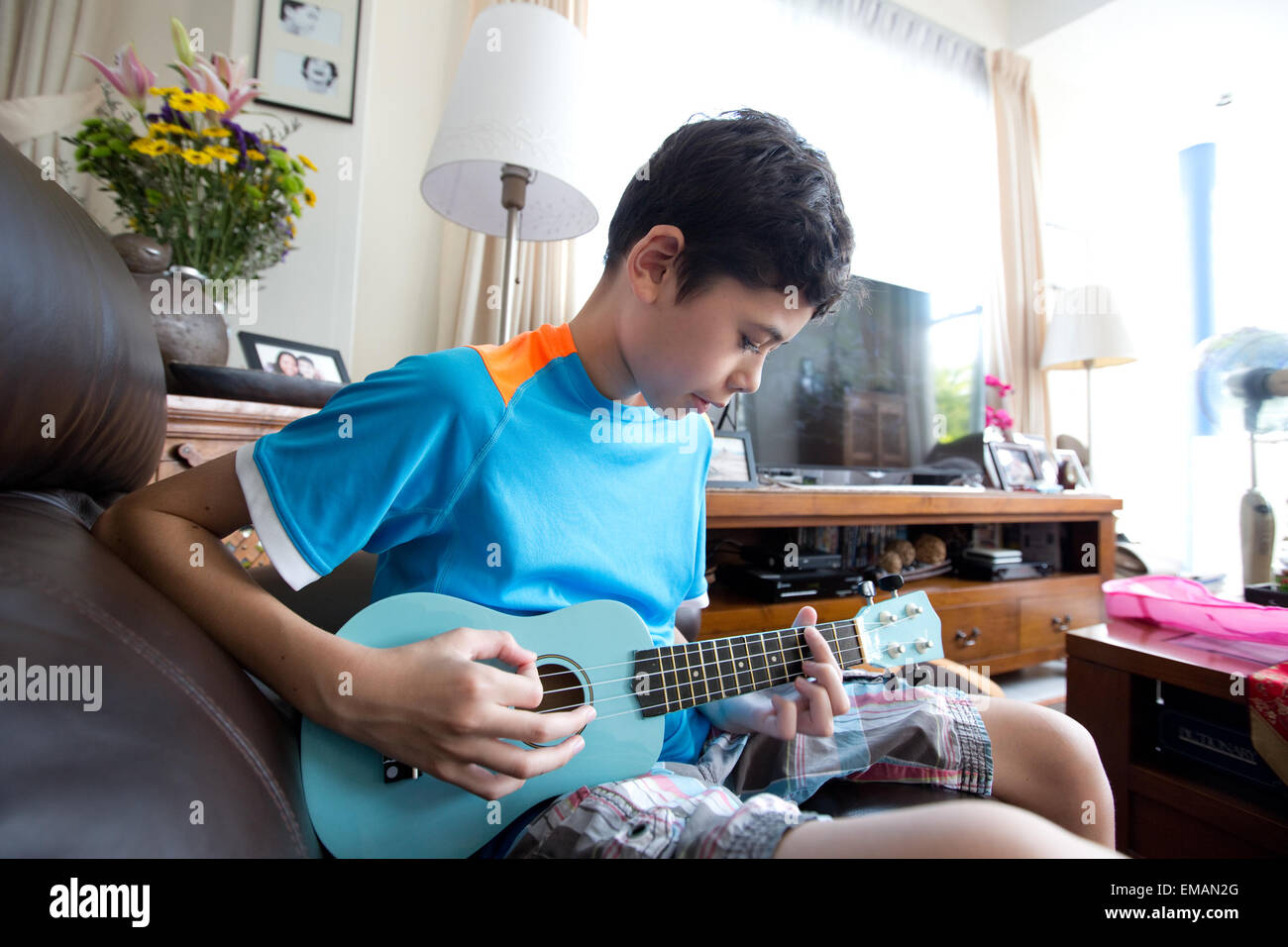 Young boy practicing on his ukulele Stock Photo - Alamy