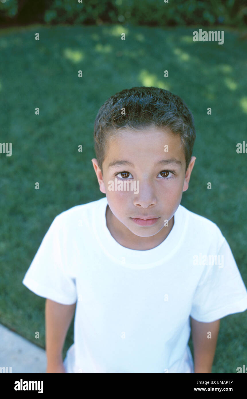 Portrait of apprehensive young boy in backyard Stock Photo - Alamy