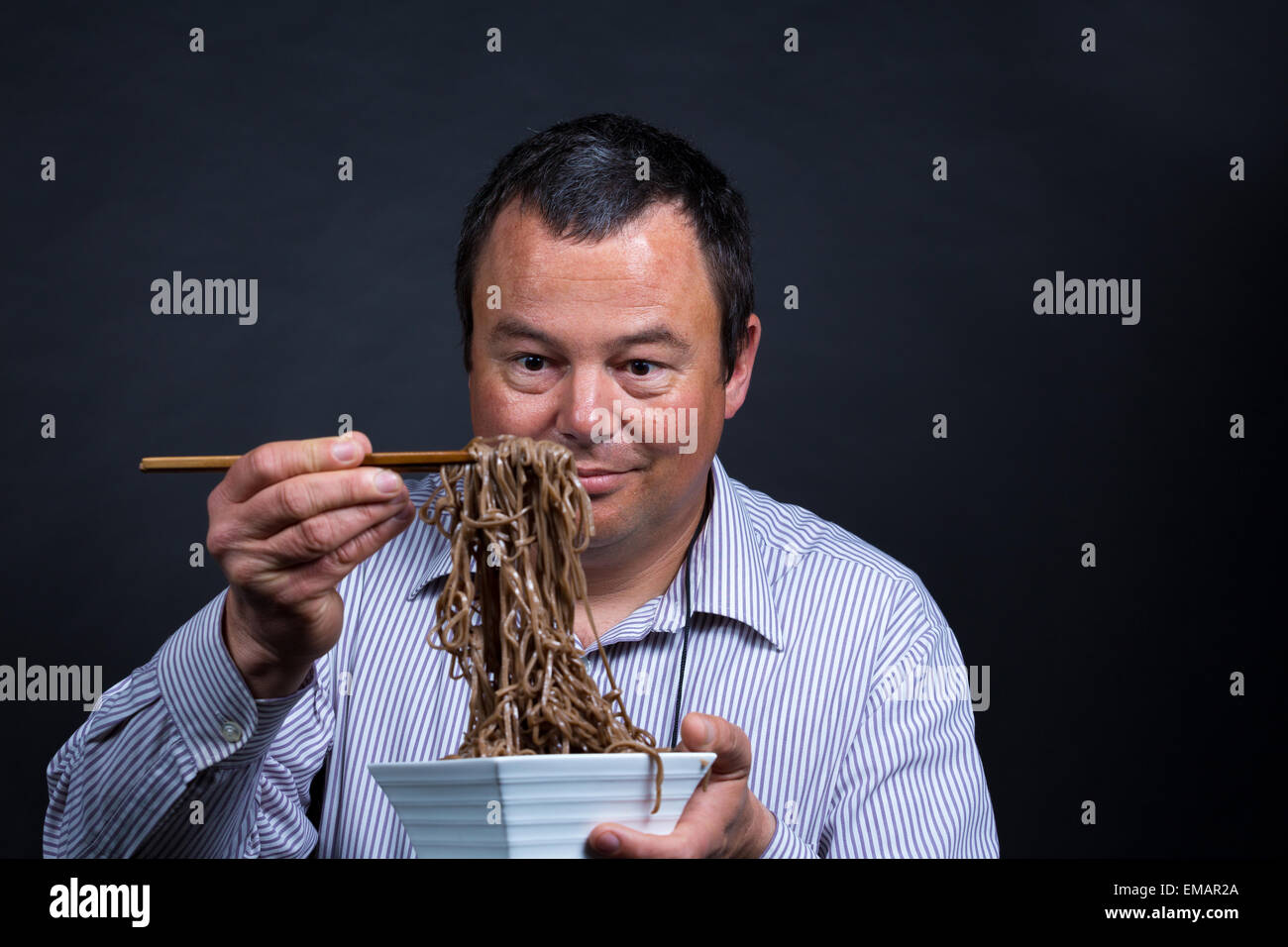 Guy experiencing how difficult it can be to eat with chopsticks Stock ...
