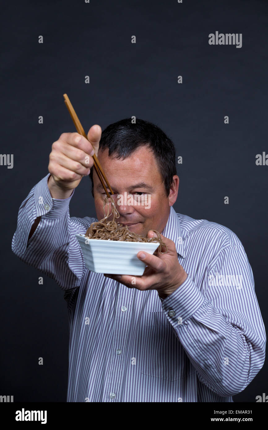 Guy getting pretty fed up with his attempts on eating with chopsticks ...