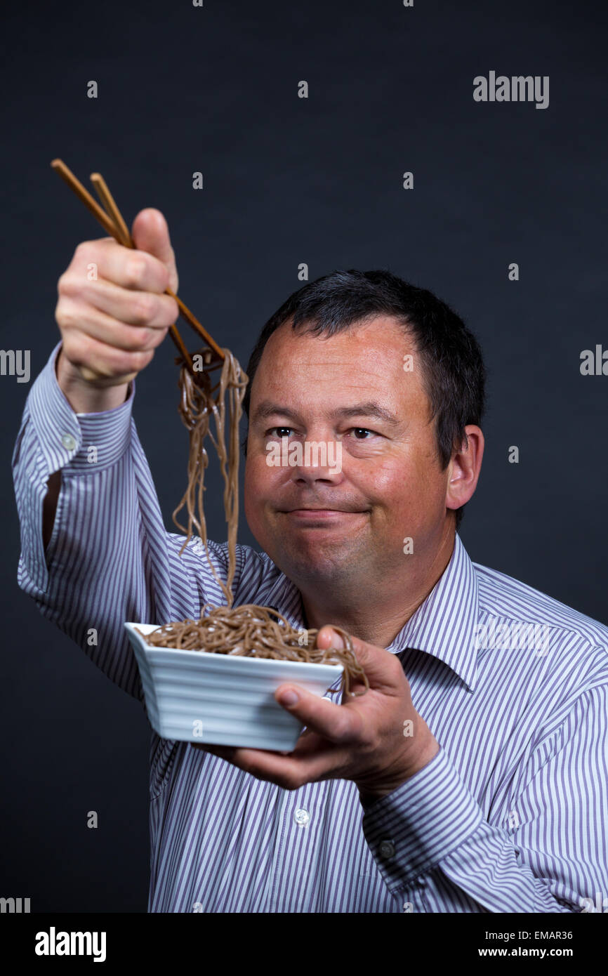 Guy getting pretty fed up with his attempts on eating with chopsticks ...