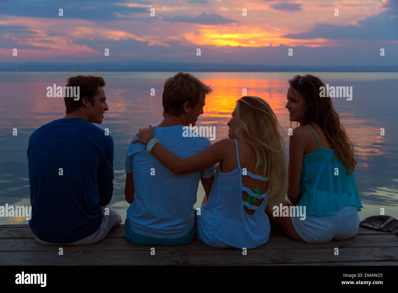 Friends group rear view at sunset happy fun together Stock Photo - Alamy