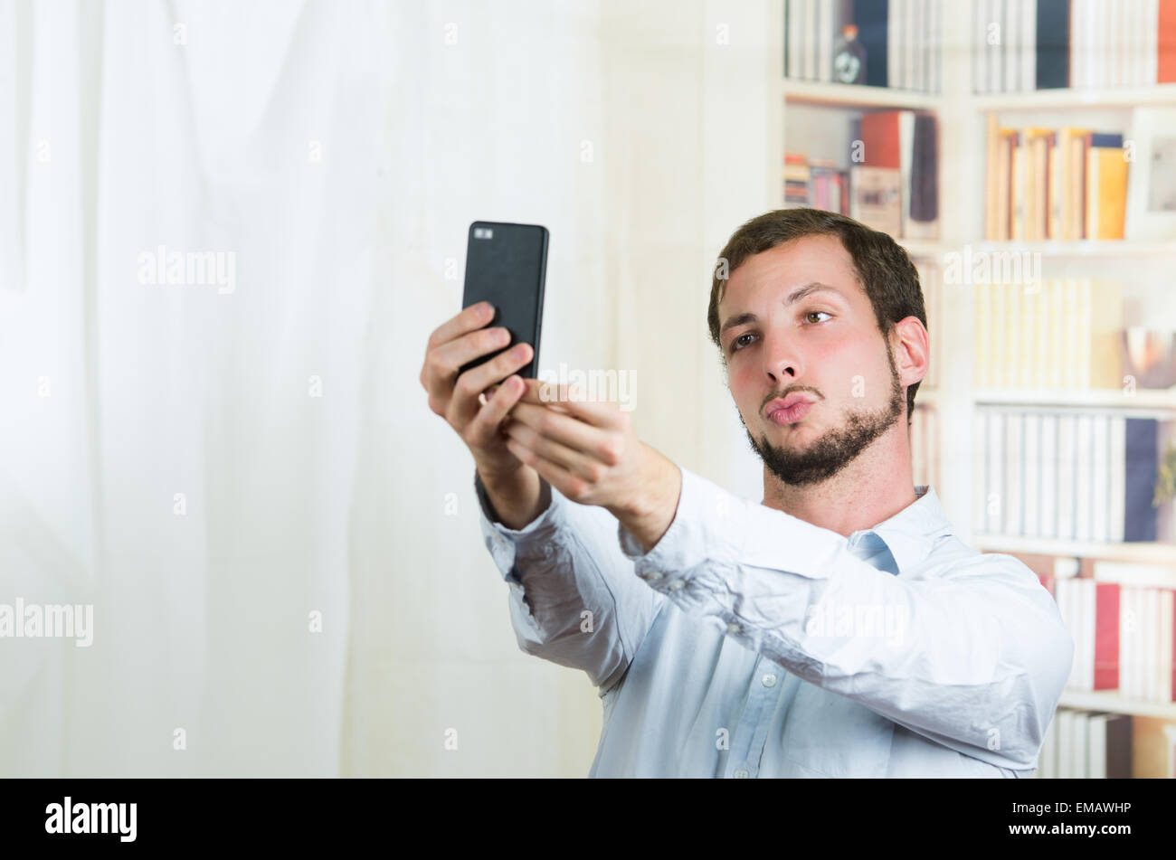 attractive young man using cell phone to take a selfie Stock Photo - Alamy