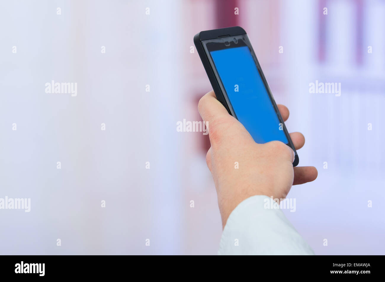 man's hand holding cell phone with empty blue screen Stock Photo - Alamy