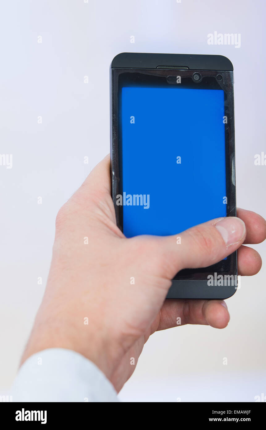 man's hand holding cell phone with empty blue screen Stock Photo - Alamy