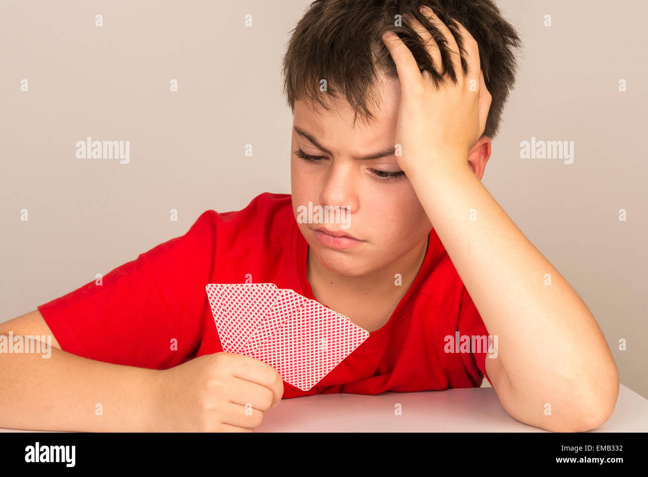 portrait of angry young boy playing cards Stock Photo - Alamy