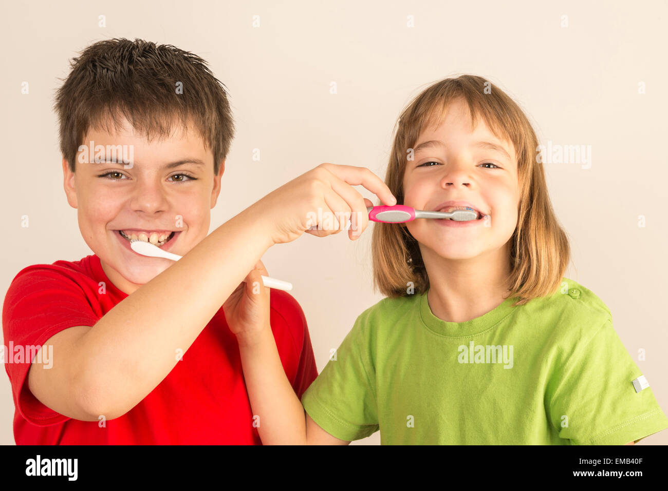 Funny portrait of a young girl and a young boy brushing each other ...