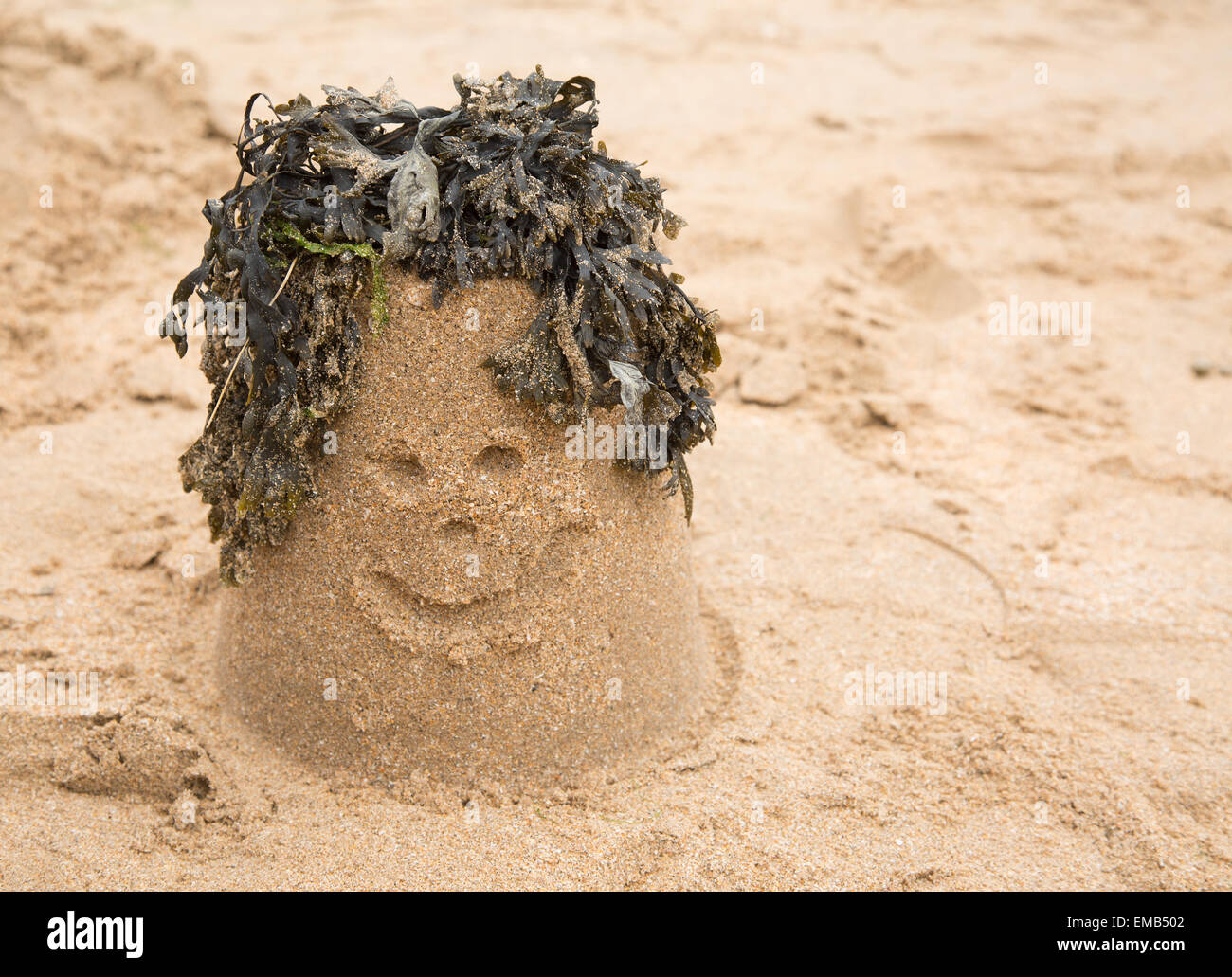Sandcastle with seaweed making a smiley face Stock Photo - Alamy