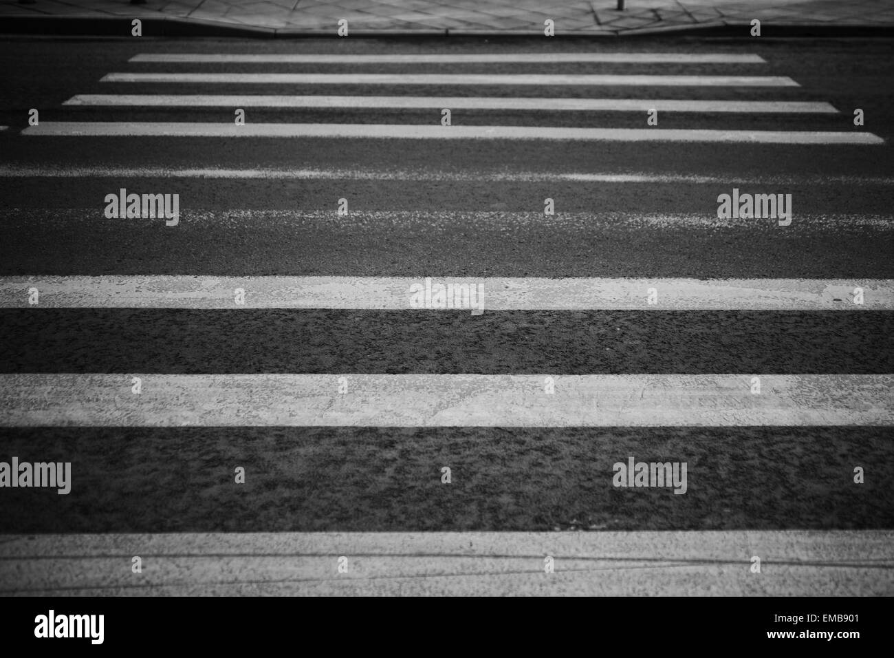 Old shabby crosswalk on black asphalt road Stock Photo - Alamy