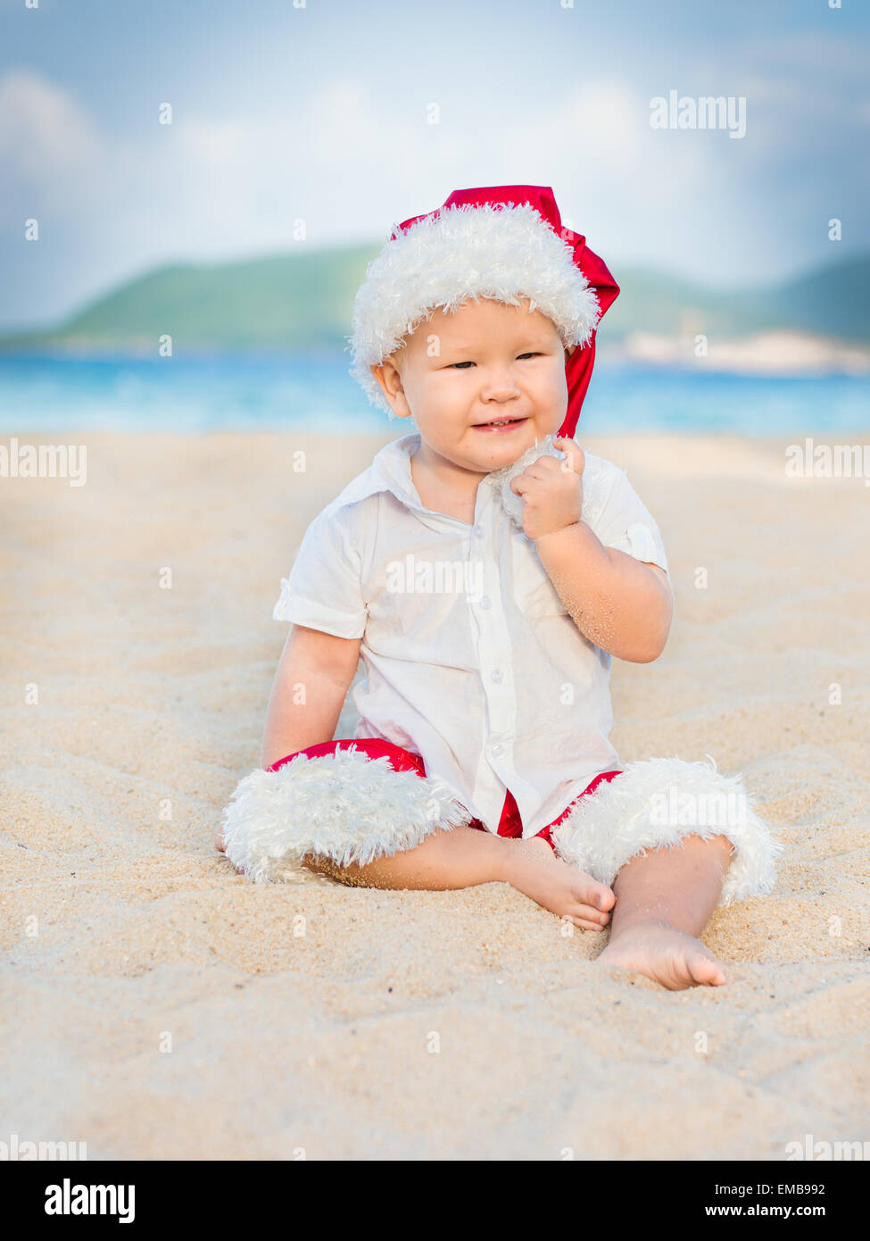 Little Santa boy on the beach Stock Photo - Alamy