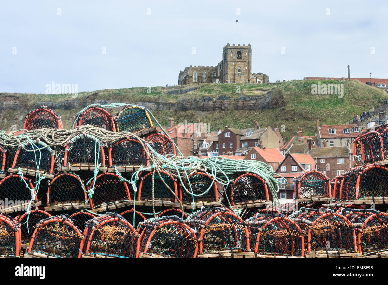 Stack of lobster pots in the harbour, with Saint Mary's Church in ...