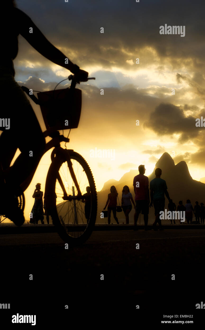 Active silhouettes of people biking and walking on sunset bike path in ...