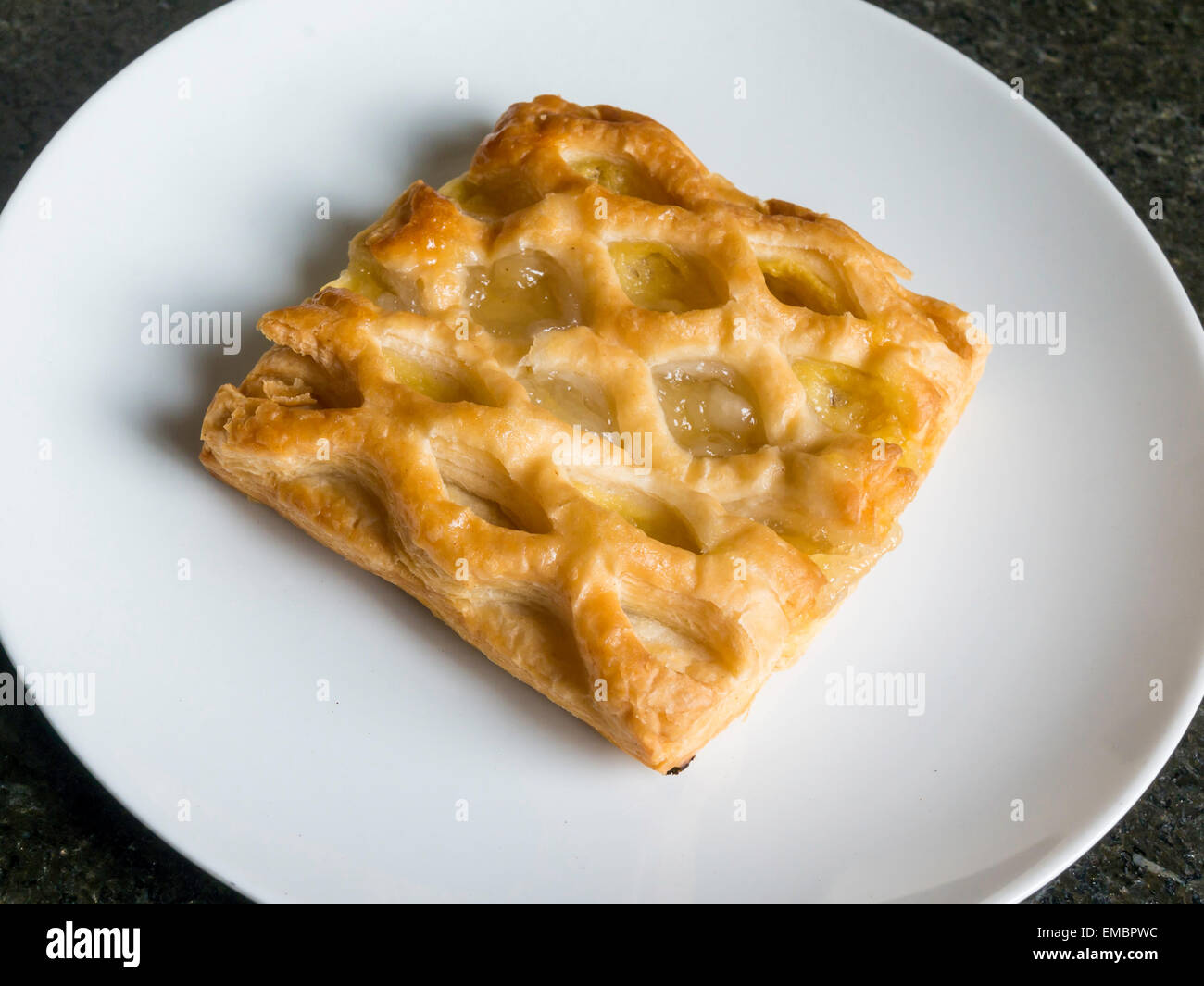 An individual portion of a lattice pastry apple and custard pie on a ...