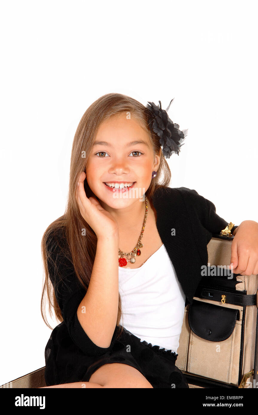A pretty smiling young girl, sitting in a briefcase, isolated for white ...