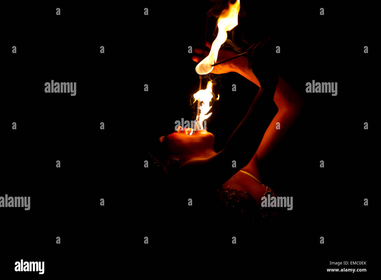 A fire eating woman swallows fire and hot flames Stock Photo - Alamy
