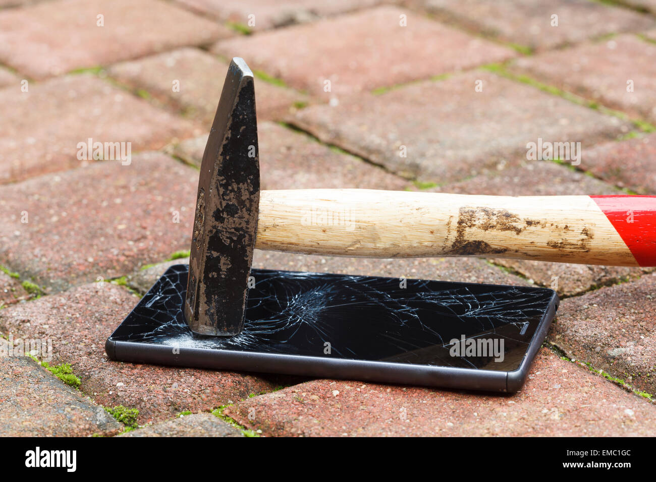 Broken mobile phone hit by hammer, lying on the pavement Stock Photo ...
