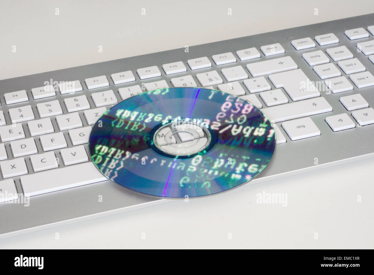 Compact disc with programming code on keyboard Stock Photo - Alamy
