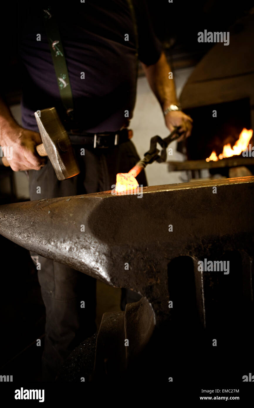 Blacksmith working with hammer at anvil Stock Photo - Alamy