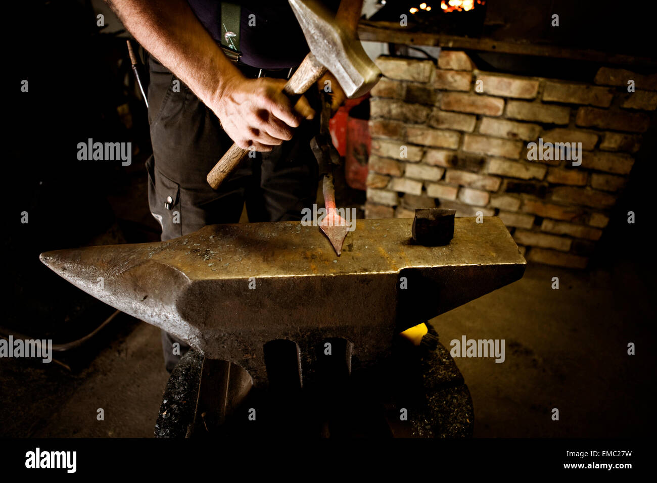 Blacksmith working with hammer at anvil Stock Photo - Alamy