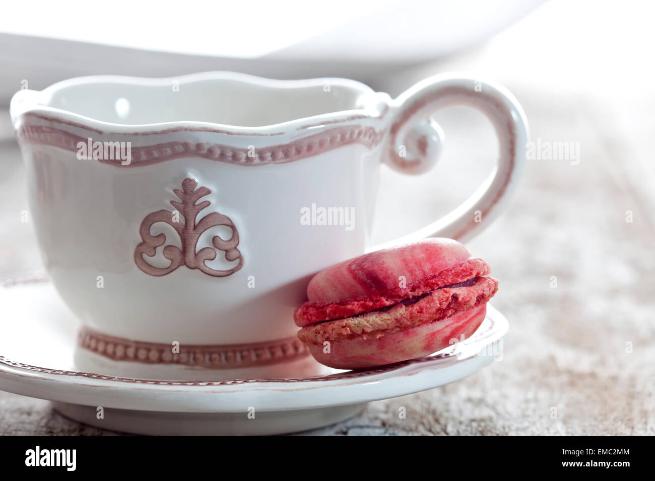 Coffee cup with raspberry macaron Stock Photo - Alamy