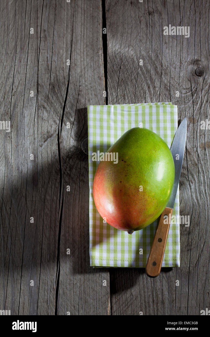 Mango, kitchen knife and cloth Stock Photo - Alamy