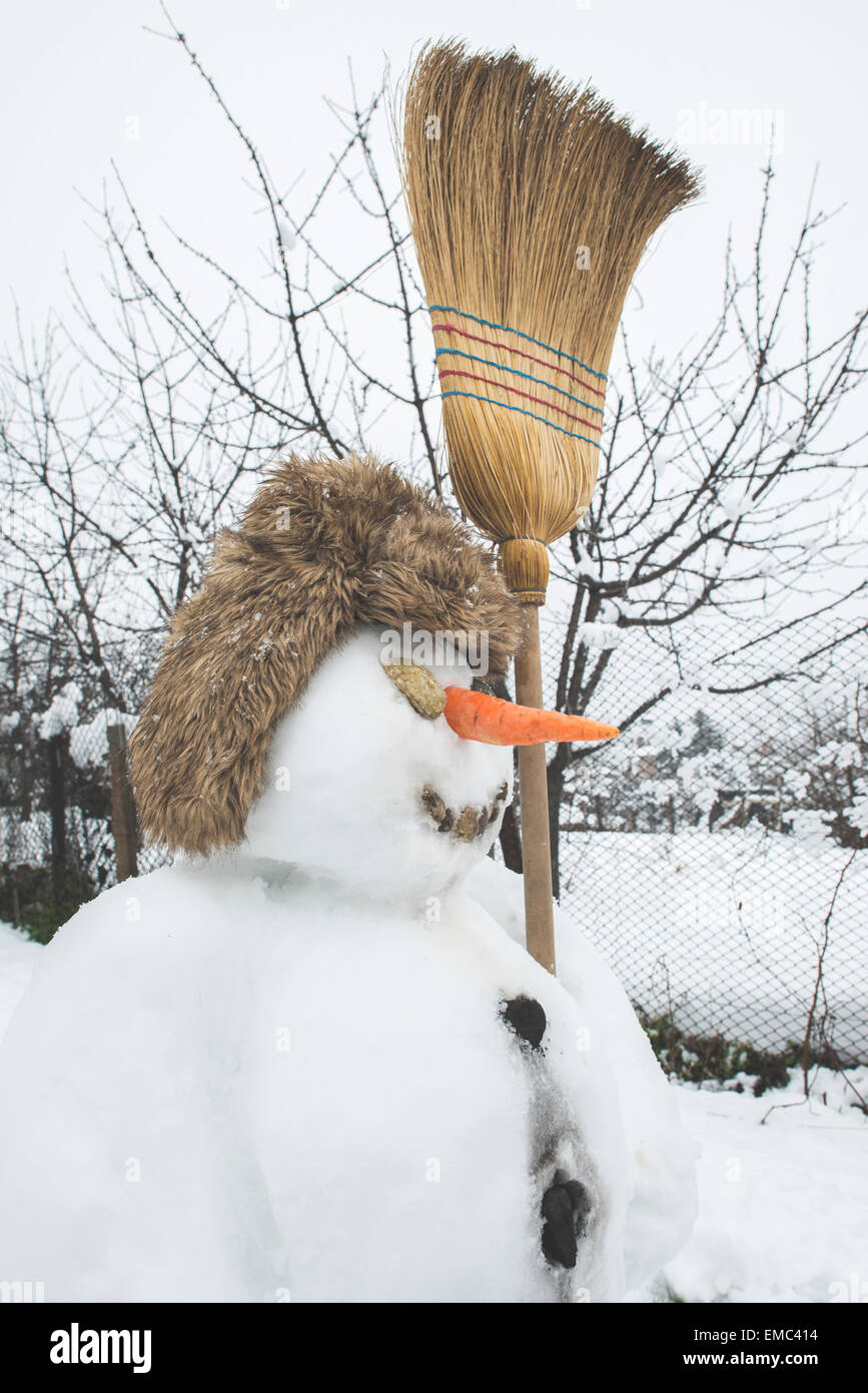 Snowman with fur cap and brush Stock Photo - Alamy