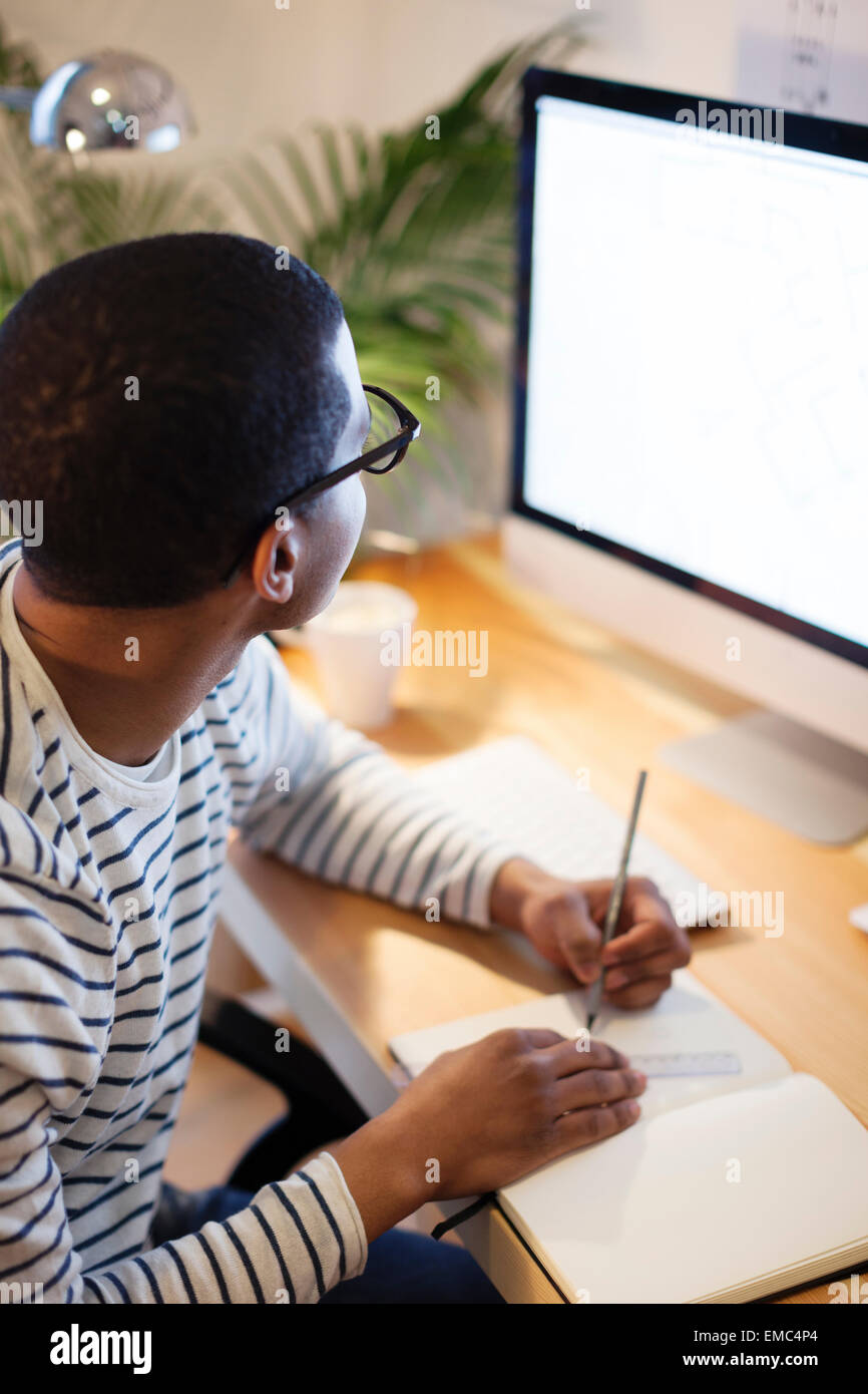 Young creative man working at computer in his home office Stock Photo ...