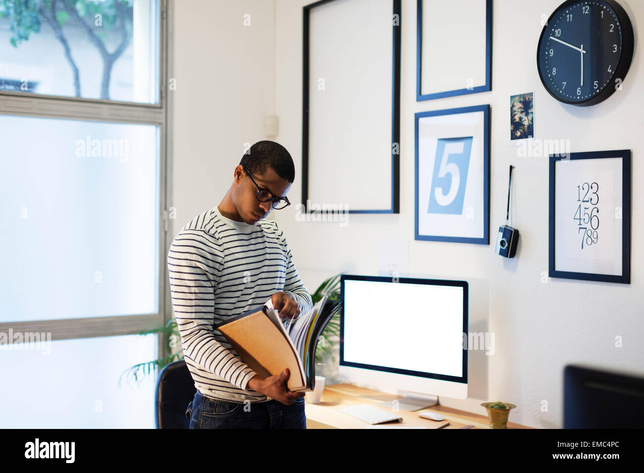 Young creative man with files in his home office Stock Photo - Alamy