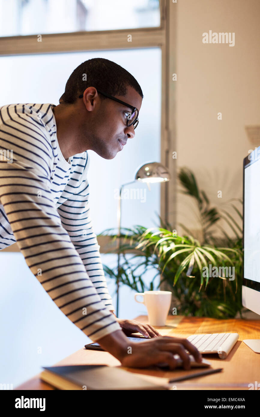 Young creative man working at computer in his home office Stock Photo ...