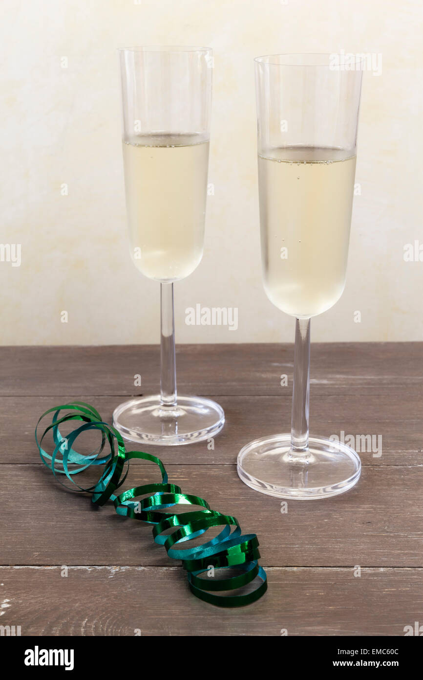Two glasses of sparkling wine and green streamer Stock Photo - Alamy