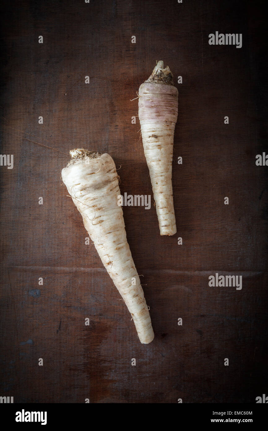 Two parsley roots on dark wood Stock Photo - Alamy