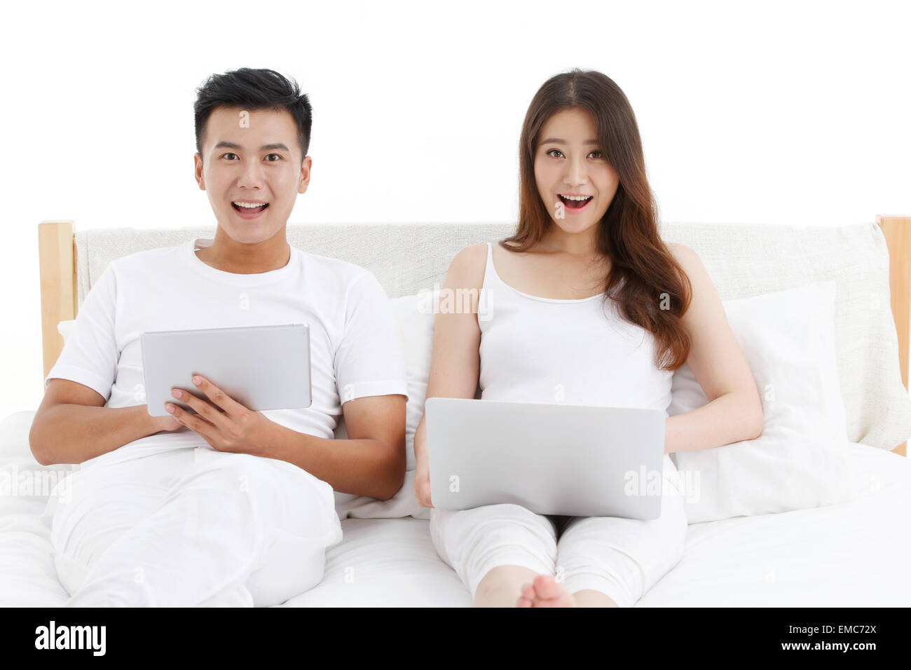 Young couples use computer in bed Stock Photo - Alamy