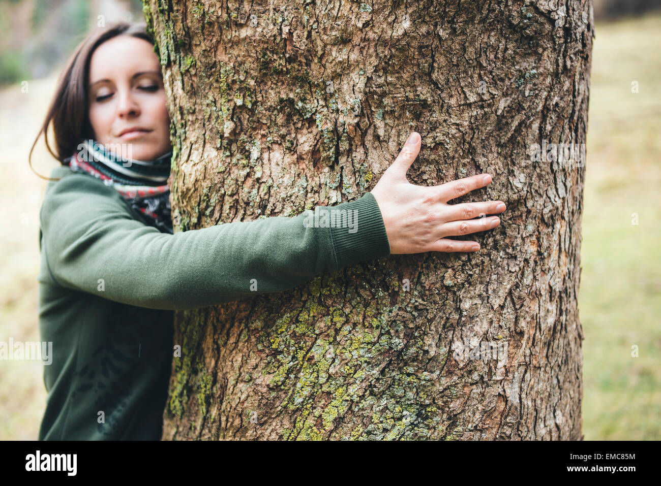Woman hugging a big tree trunk Stock Photo - Alamy