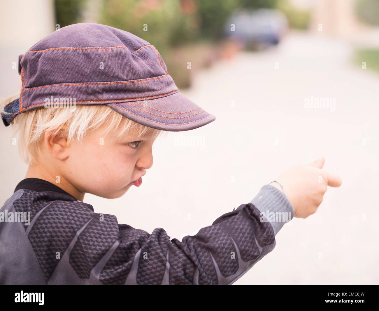 Blond boy playing, making shooting gesture Stock Photo - Alamy
